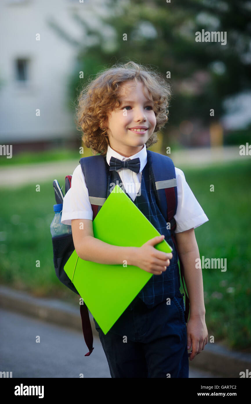 Elegant fair-haired first-grader in the school yard. The student looks ...