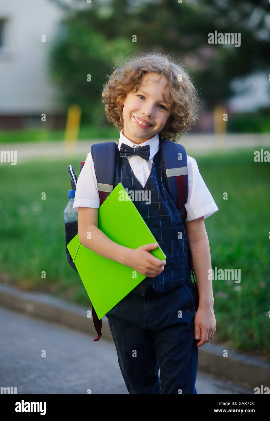 Elegant curly-haired first-grader in the school yard. The student looks ...