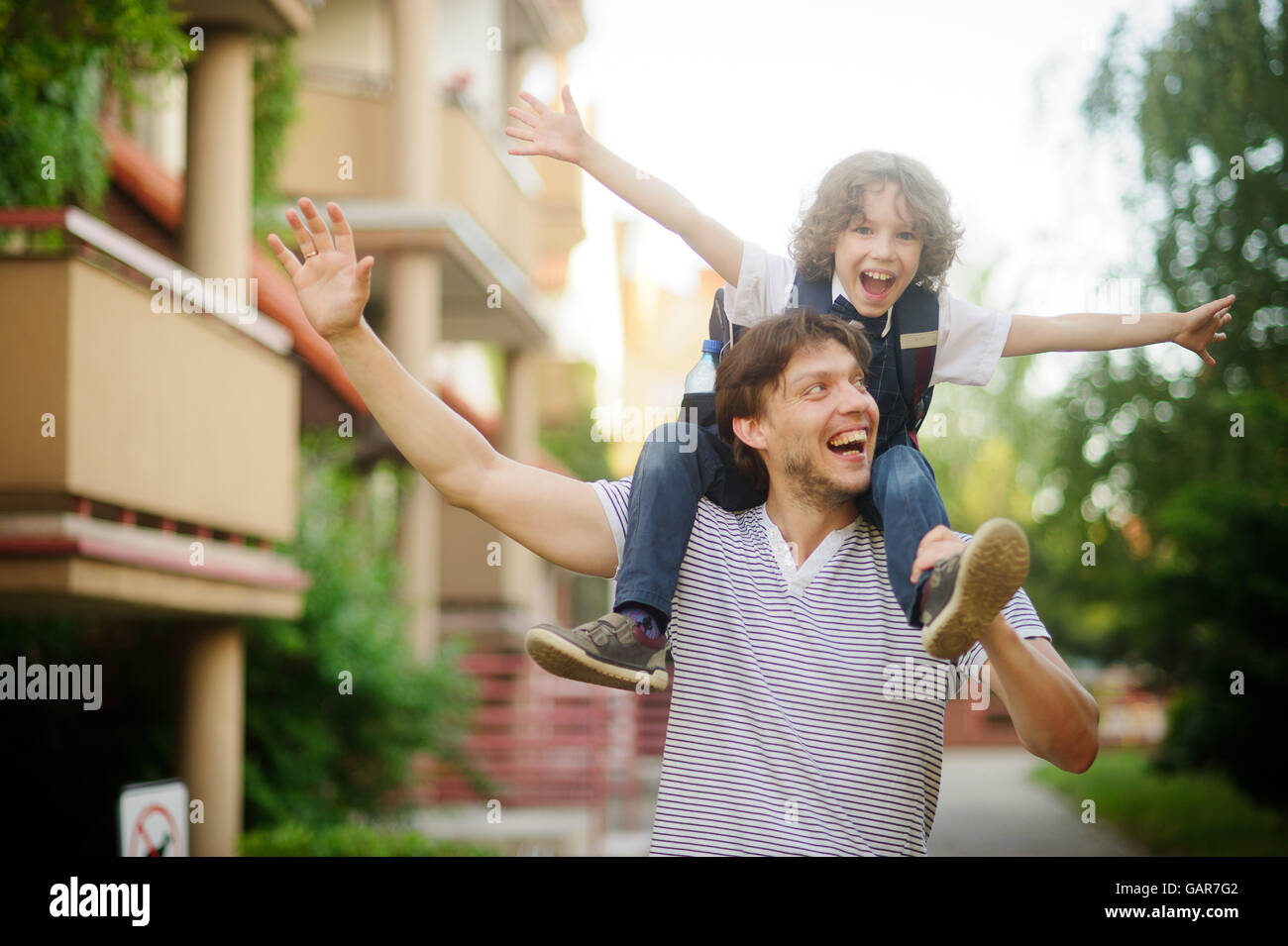 First grader sitting on the shoulders of his father. He is very happy ...