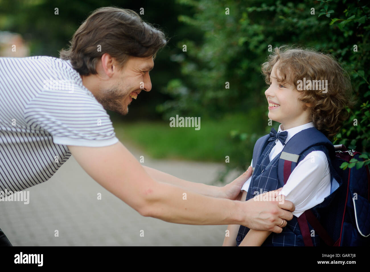 The father sees his son first-grader at the school. He leaned over to ...