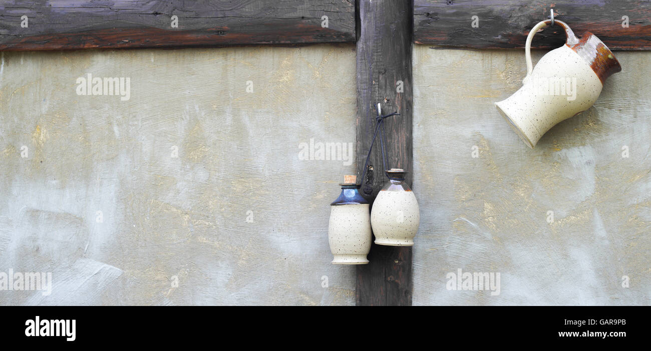 Three white jugs hanging on the wall Stock Photo - Alamy