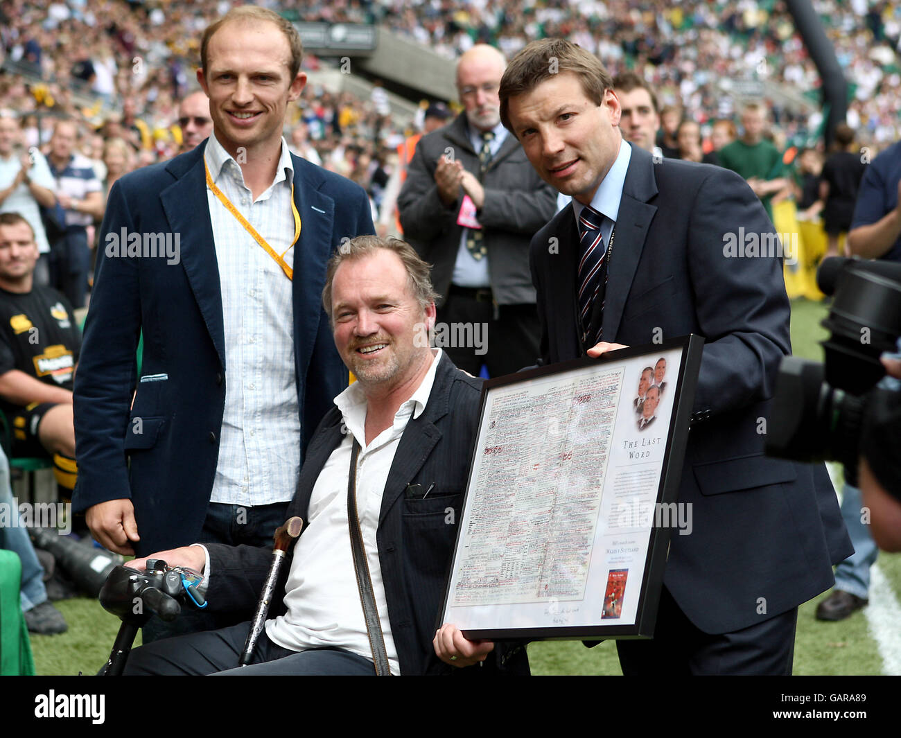 BBC Rugby commentator Alastair Hignell (c) receives an award to mark ...