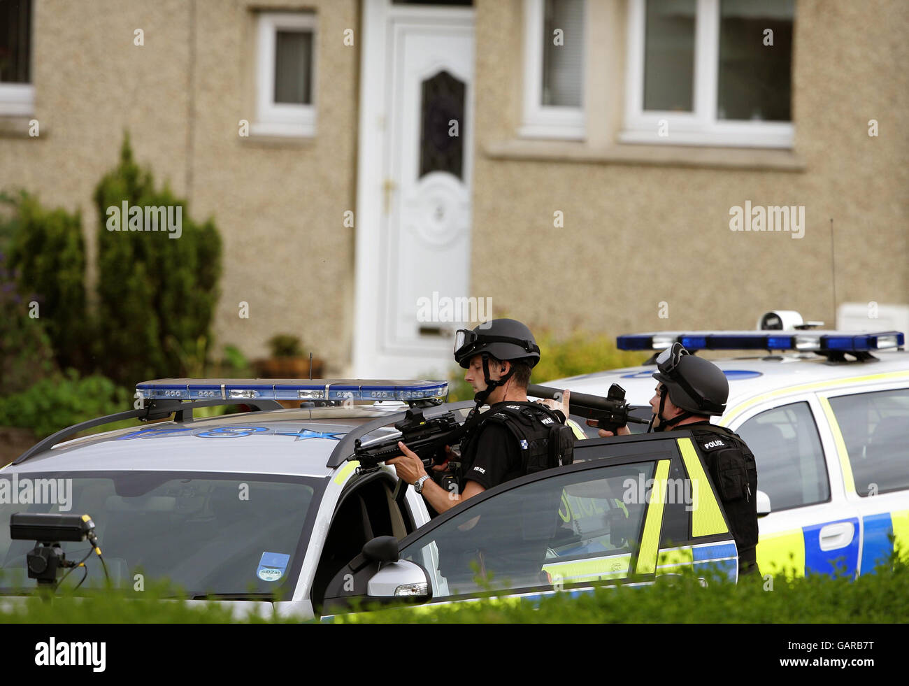 Armed police officers outside a house in Falkirk. Officers from Central ...