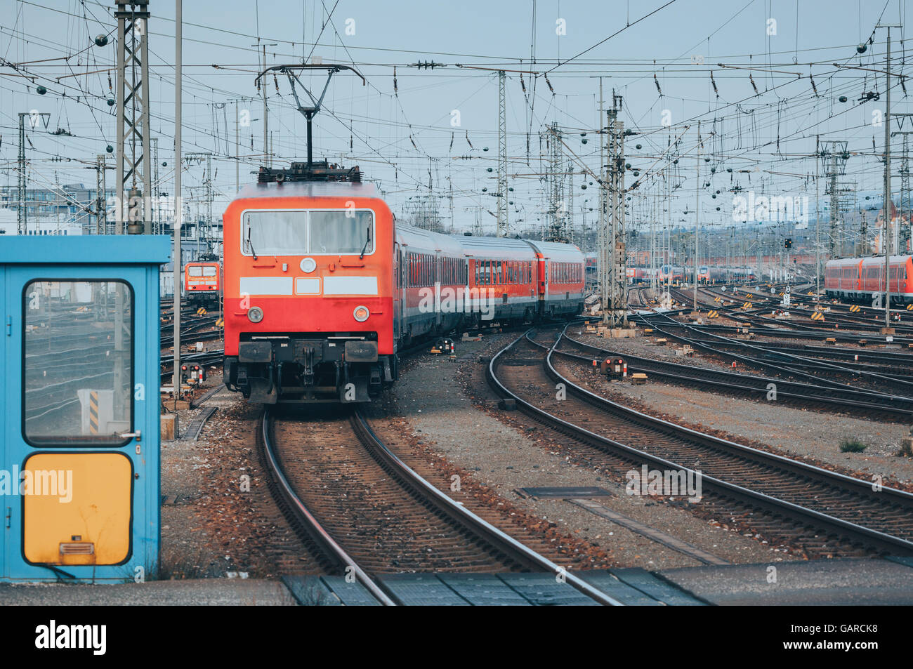 Railway station with modern red commuter train in motion in the evening ...