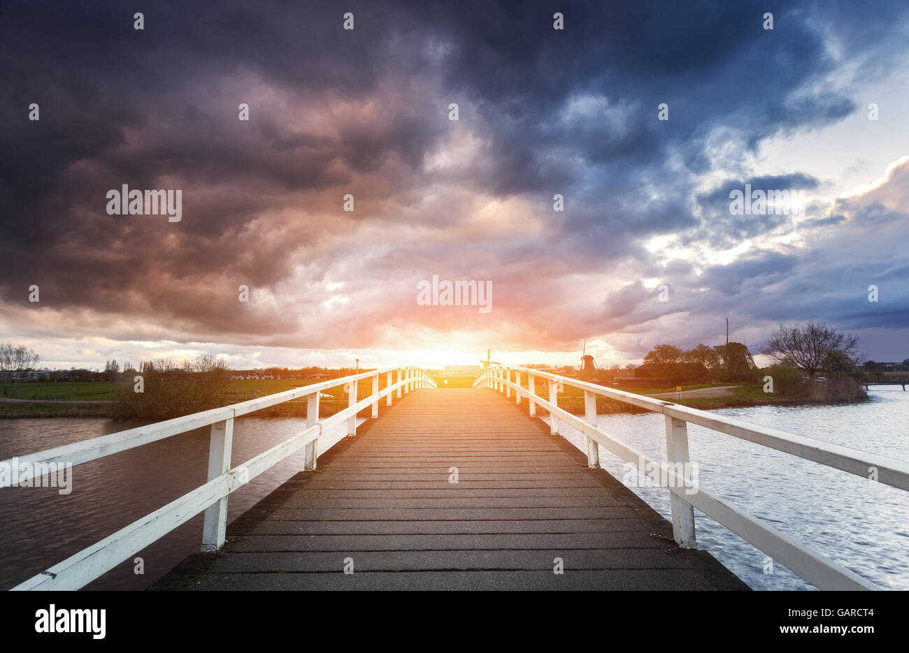 Beautiful wooden bridge on the background of dramatic cloudy sky at ...