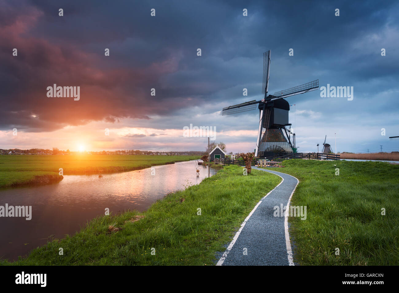 Landscape with traditional dutch windmills and path near the water ...