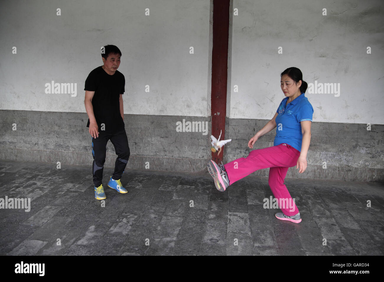 Chine couple play Jianzi, a sport game in which players keep a heavily ...