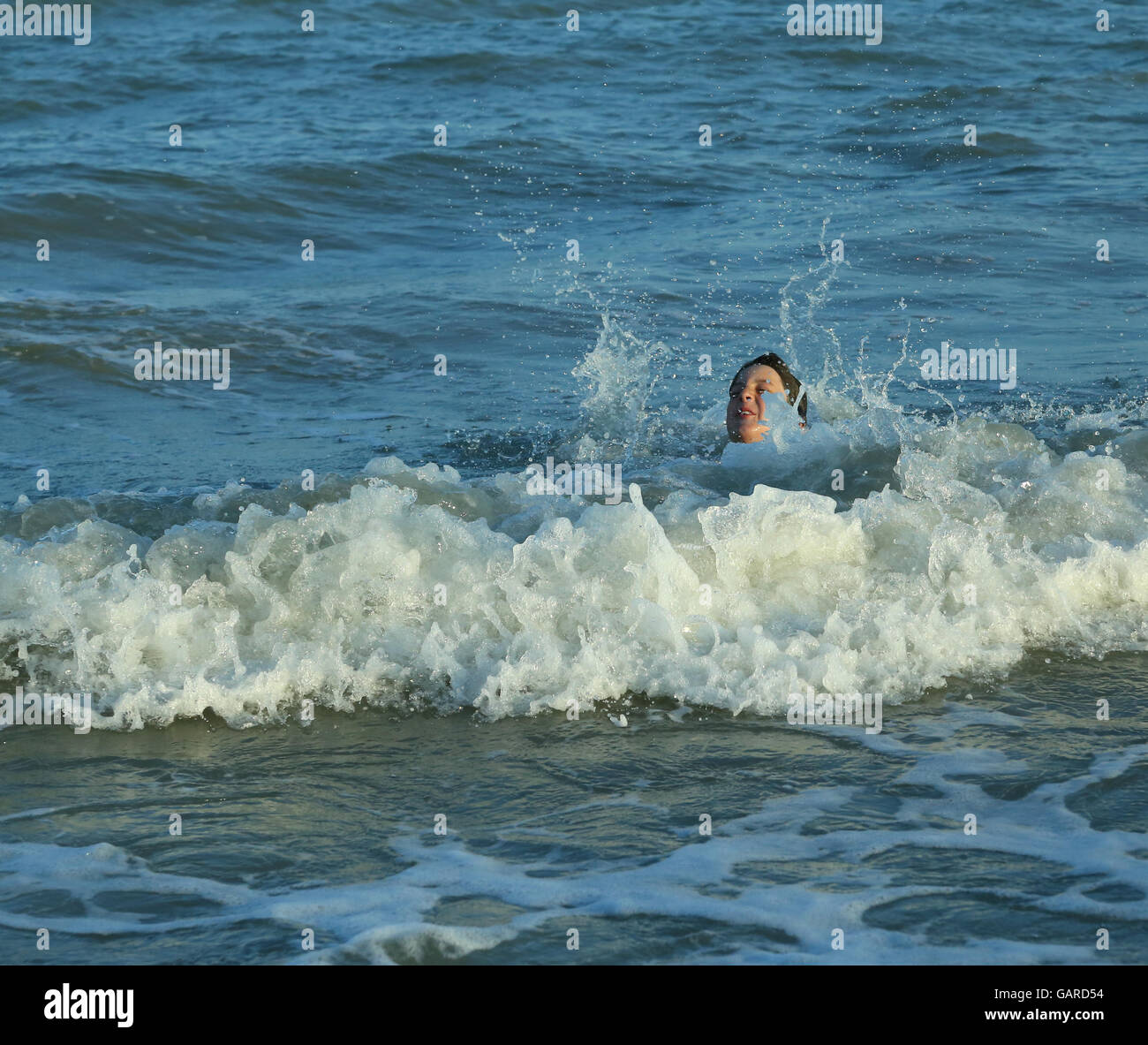 Child playing in the waves hi-res stock photography and images - Alamy