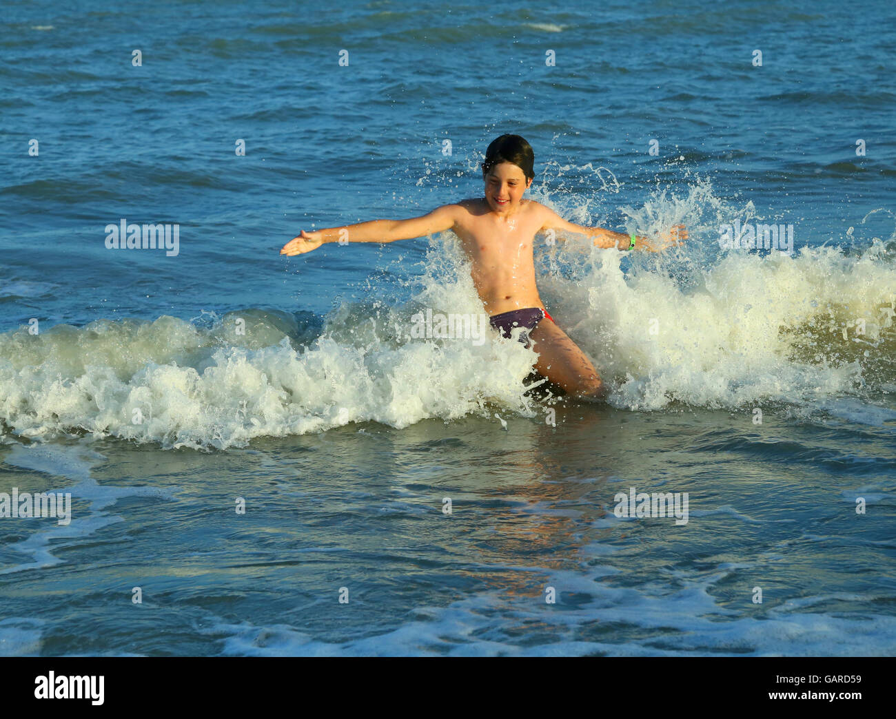 Happy boy jumping in waves hi-res stock photography and images - Alamy
