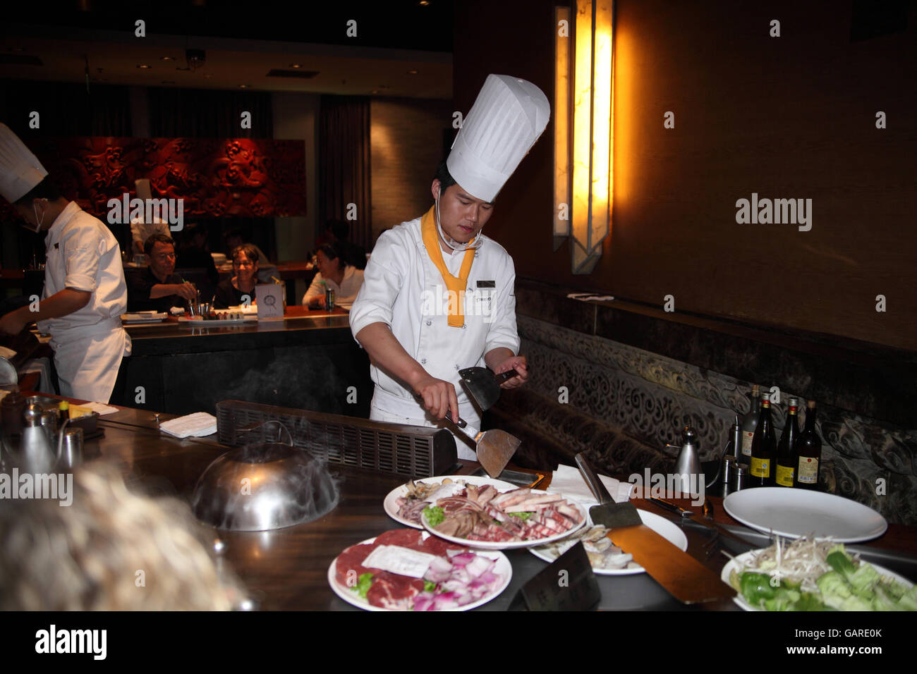 A Chinese cook in an authentic Chinese restaurant, wearing white ...