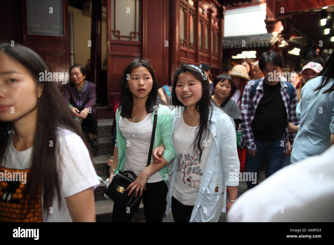 Young and happy Chinese women and many other tourists walk in the ...