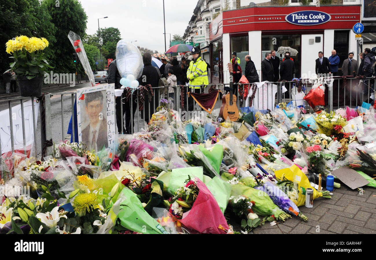 Crowds look at floral tributes opposite the Three Cooks bakery south ...