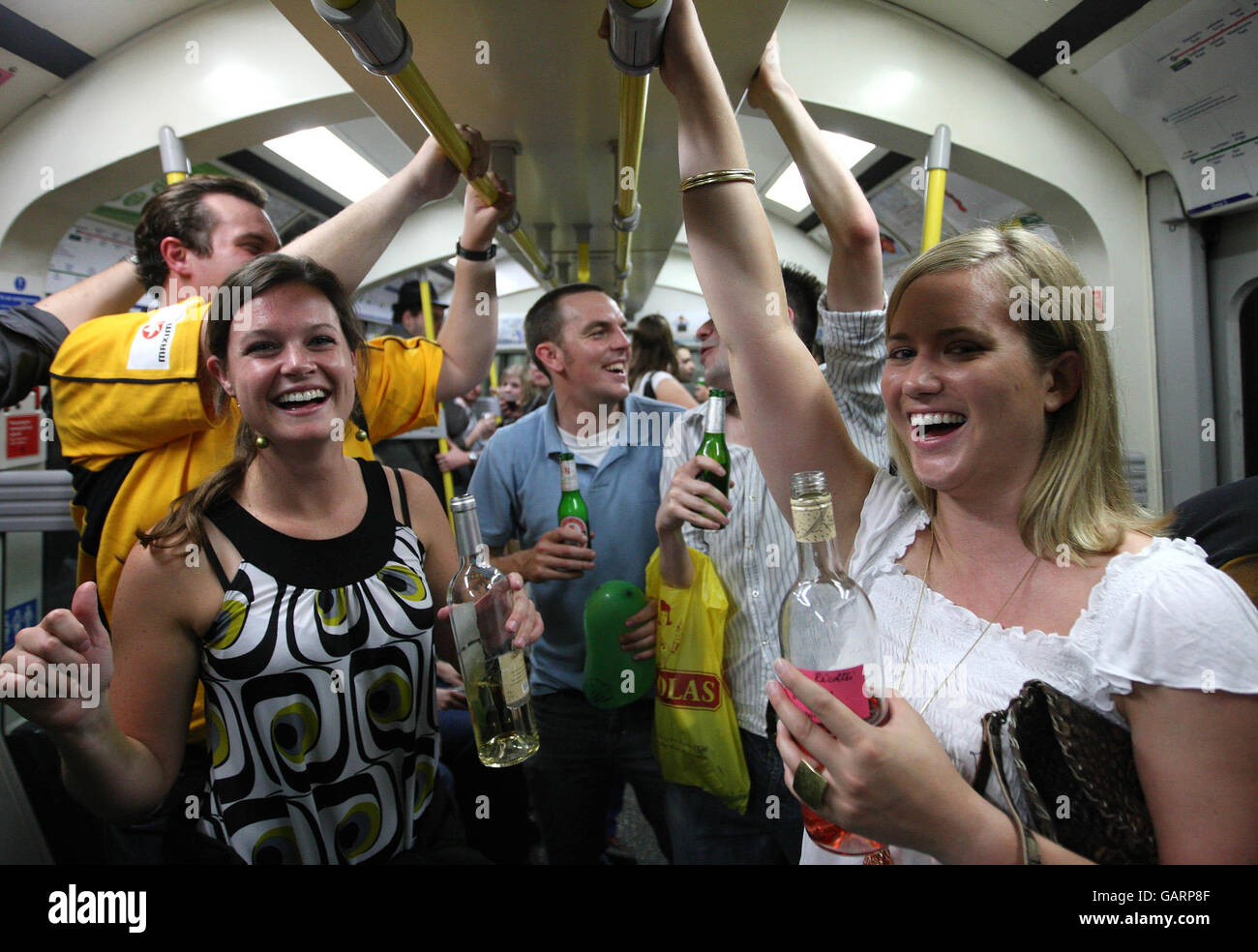 Revellers drink on a Circle line tube train, before the ban on drinking ...