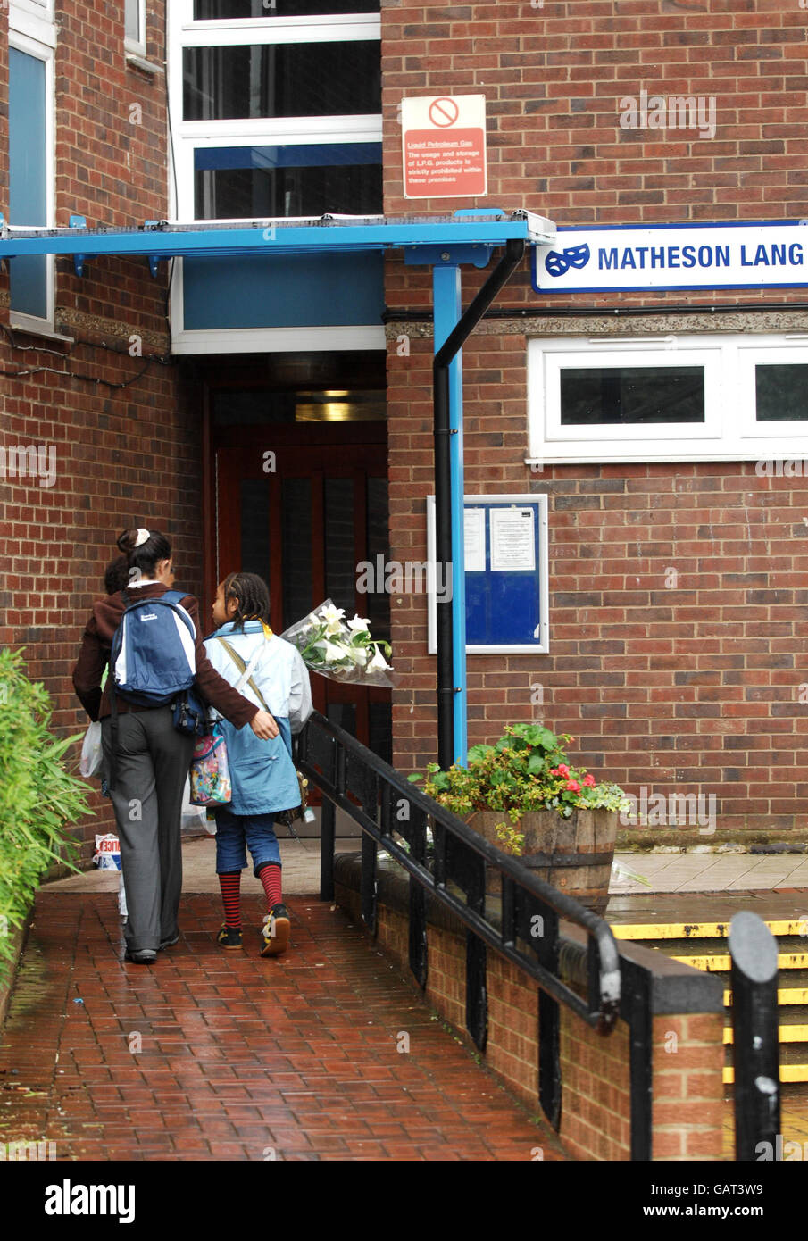 Three mourners lay flowers outside the block of flats in Matheson Lang ...