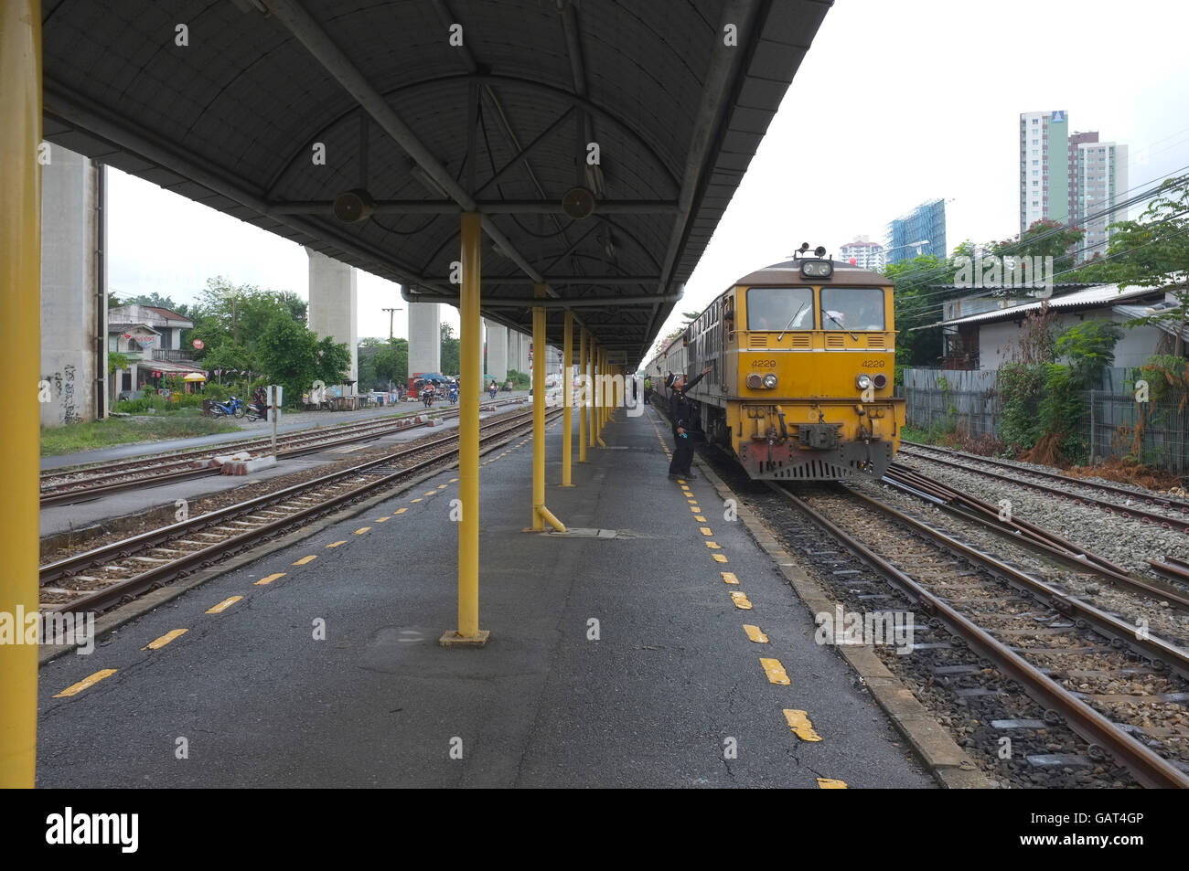 Railway station with yellow train arrival Stock Photo - Alamy