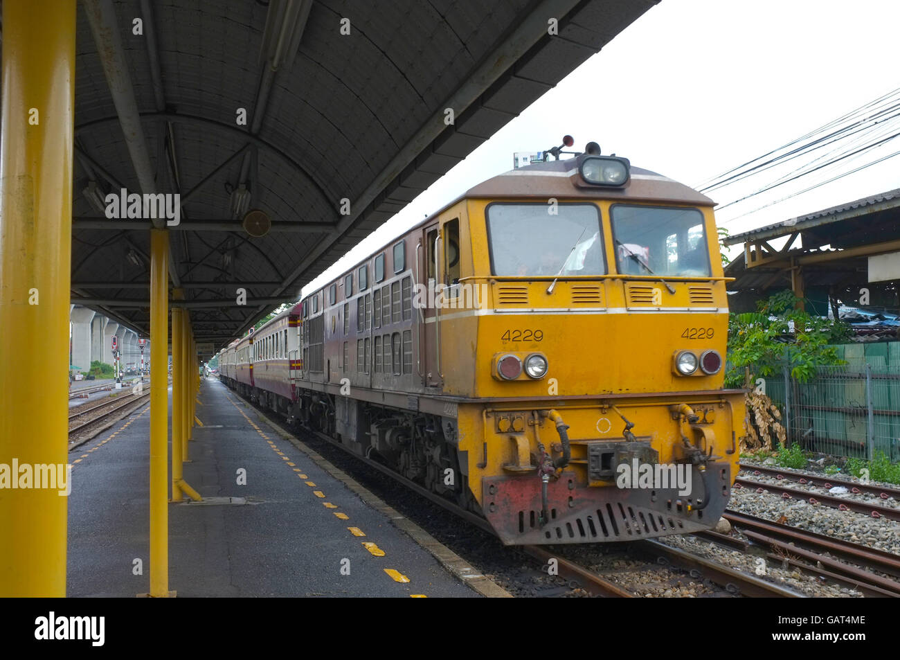 Railway station with yellow train arrival Stock Photo - Alamy