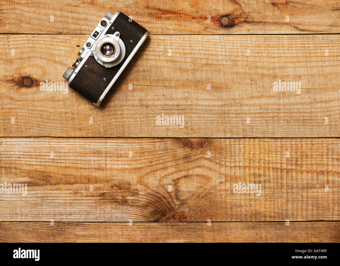 Vintage, very old film camera on brown wooden background and space for ...