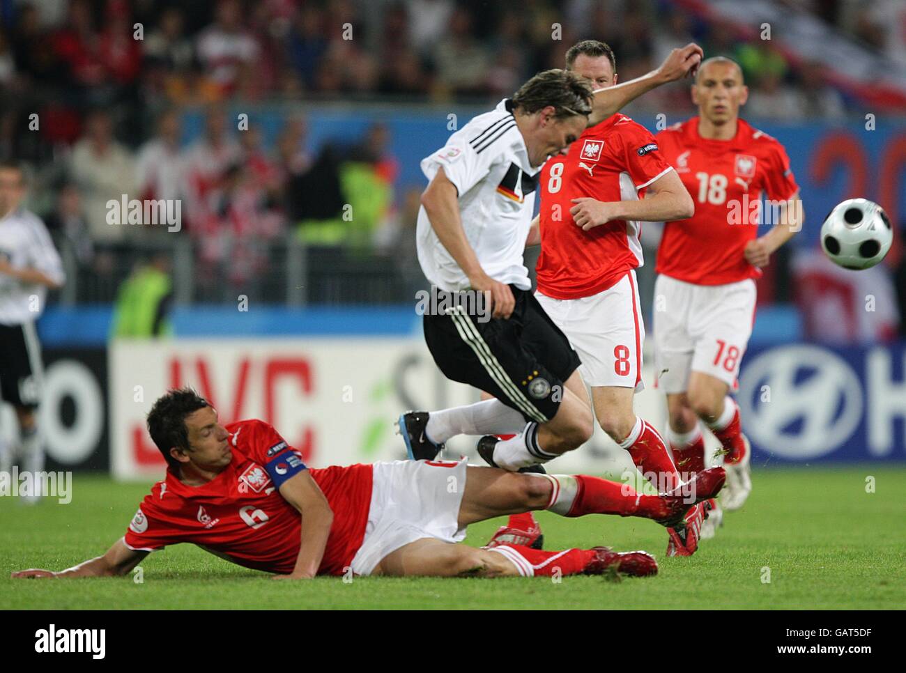 Poland's Jacek Bak (left) slides in to challenge Germany's Clemens ...