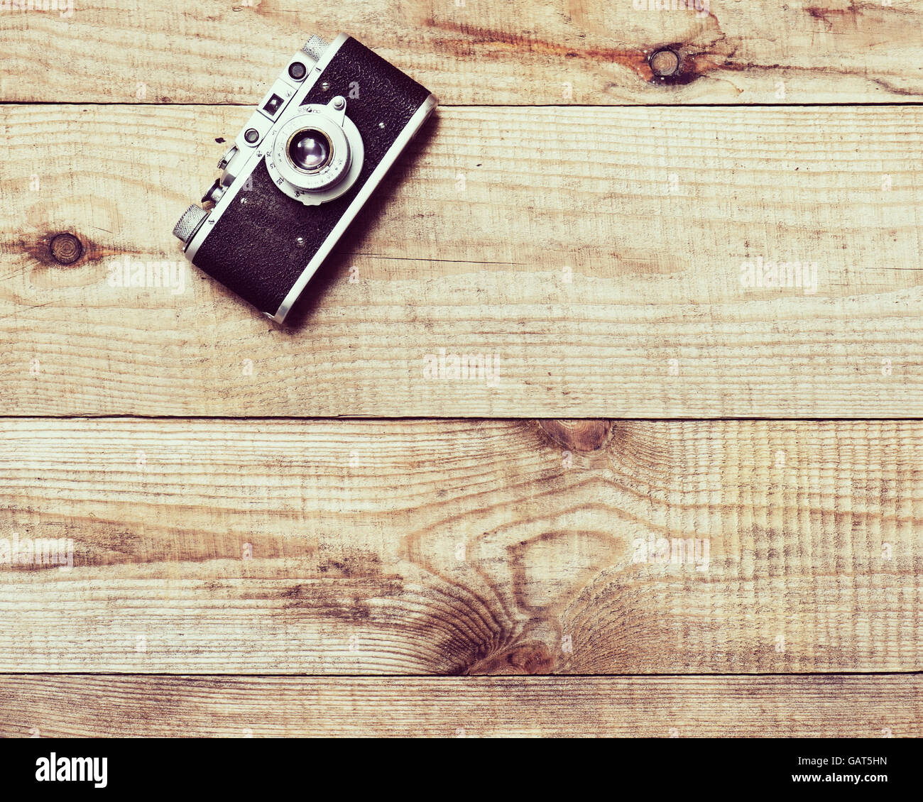Vintage, very old film camera on brown wooden background and space for ...