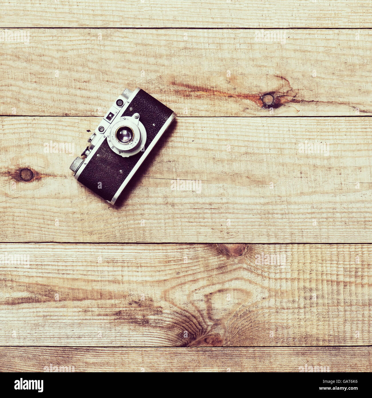 Vintage, very old film camera on brown wooden background and space for ...