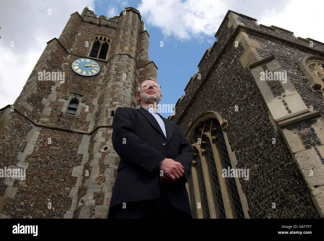 The Rev Nigel Hartley stands in front of the bell tower at St Peter and ...