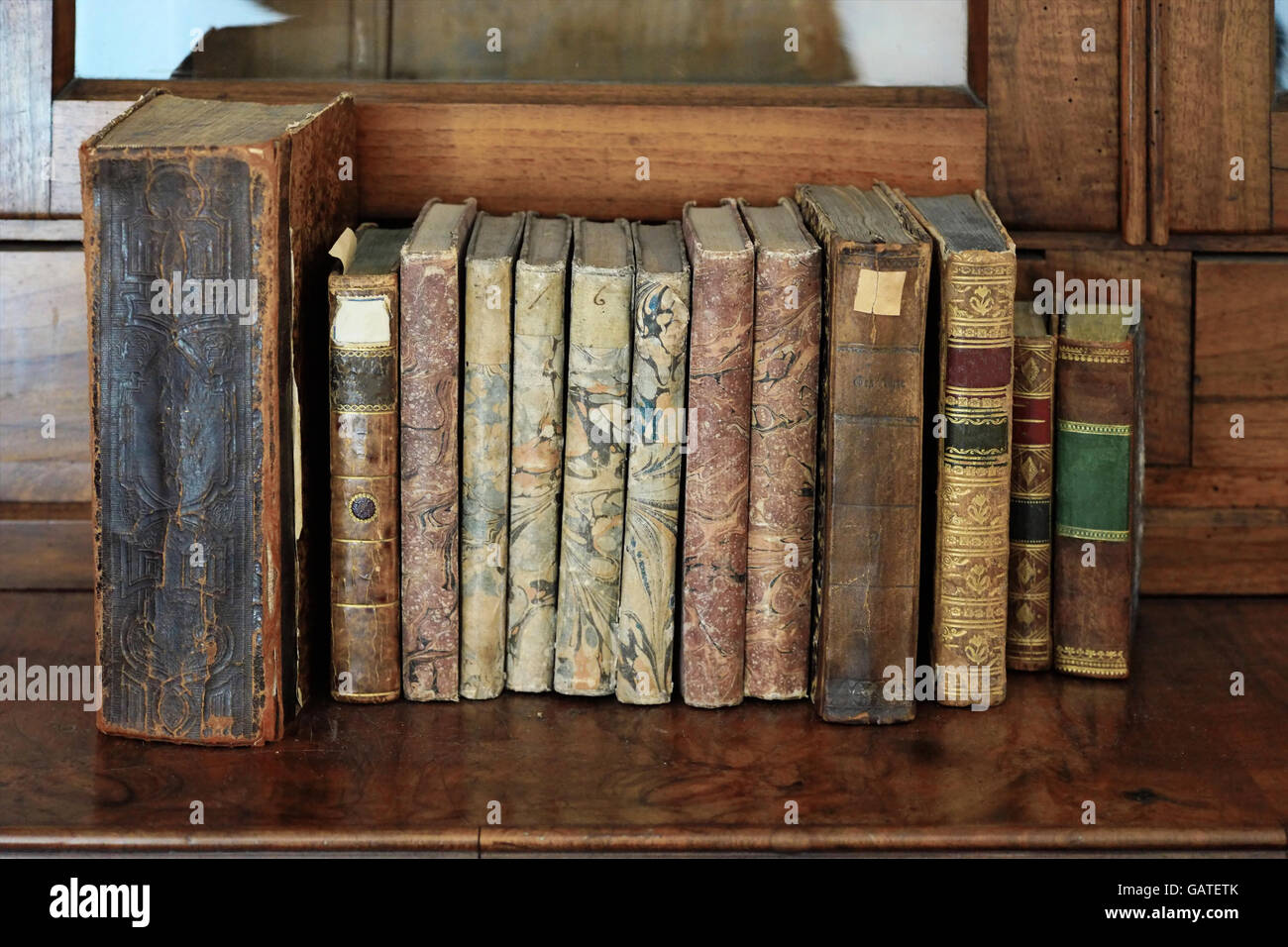Very old books in a row on a book shelf Stock Photo - Alamy