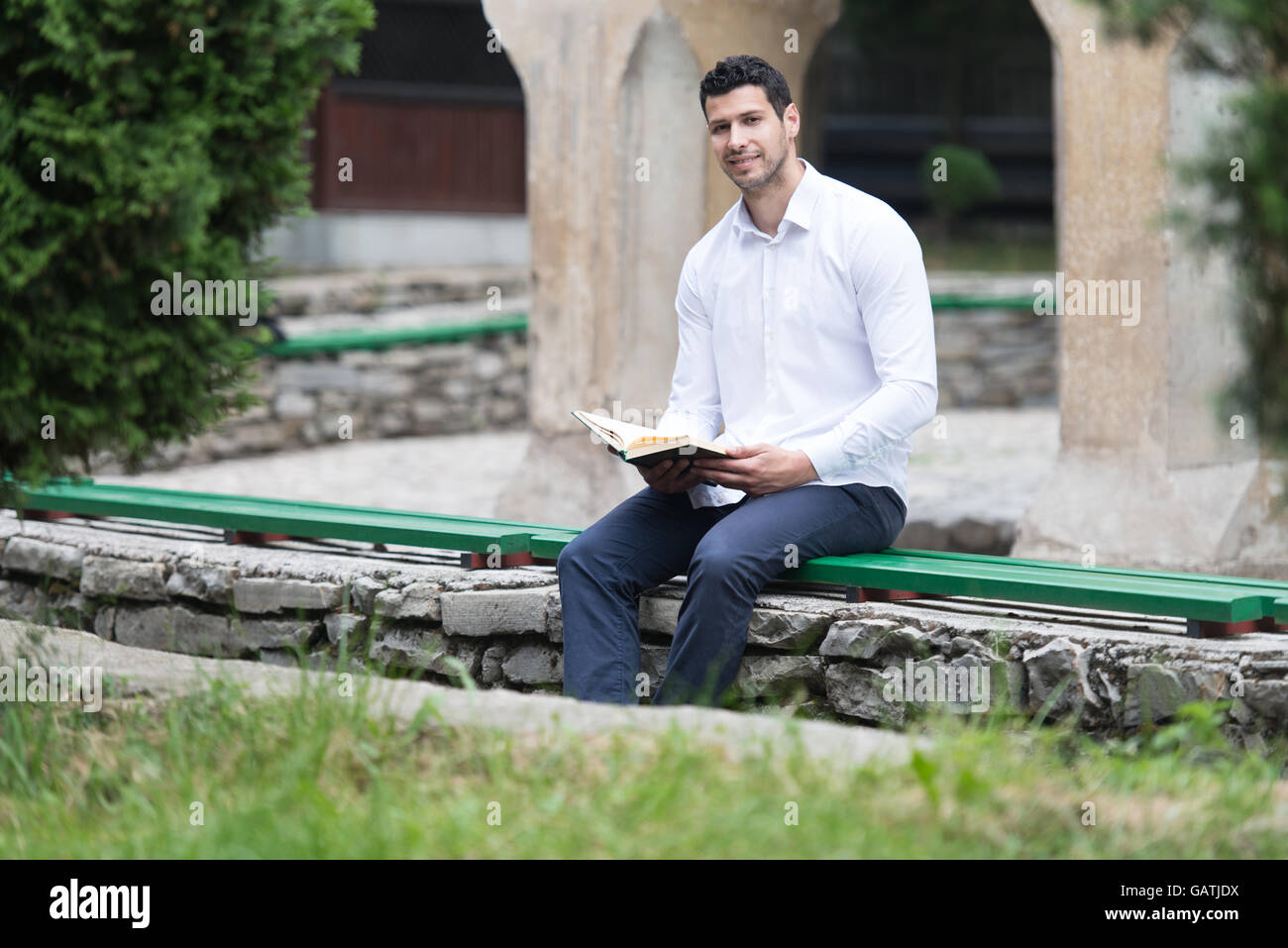Adult Muslim Man Is Reading The Koran Outdoors Stock Photo - Alamy