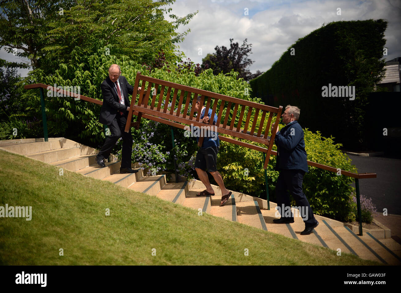 A bench is moved up steps on day eight of the Wimbledon Championships ...