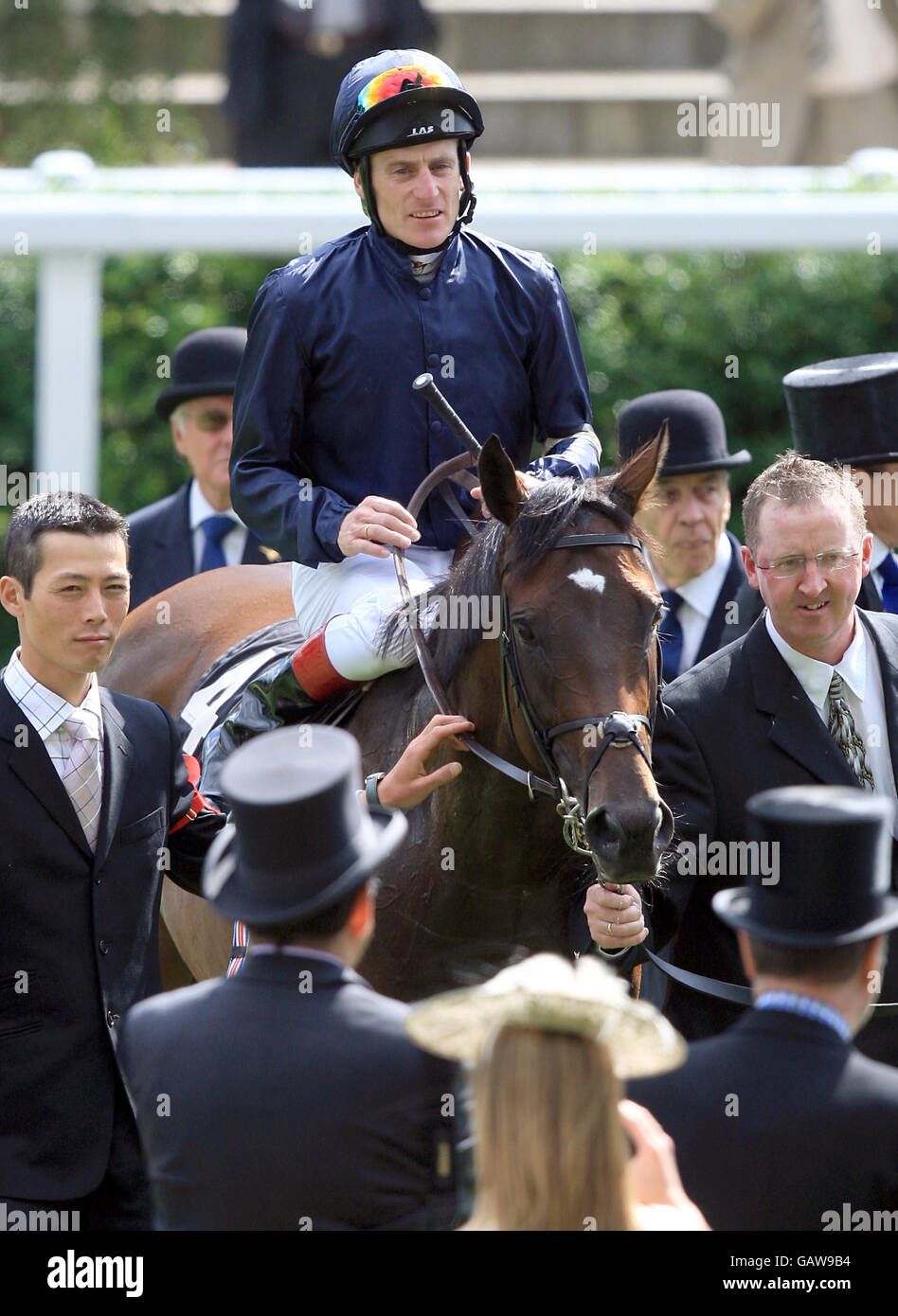 Jockey Johnny Murtagh (c) enters the winner's enclosure after taking ...