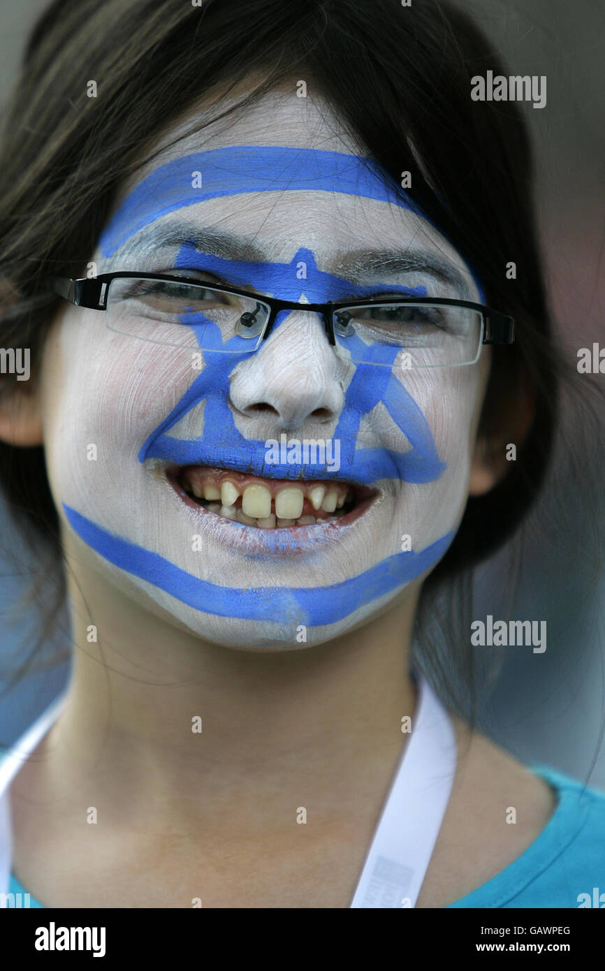 A young girl with her face painted in the Israeli colours takes part in ...