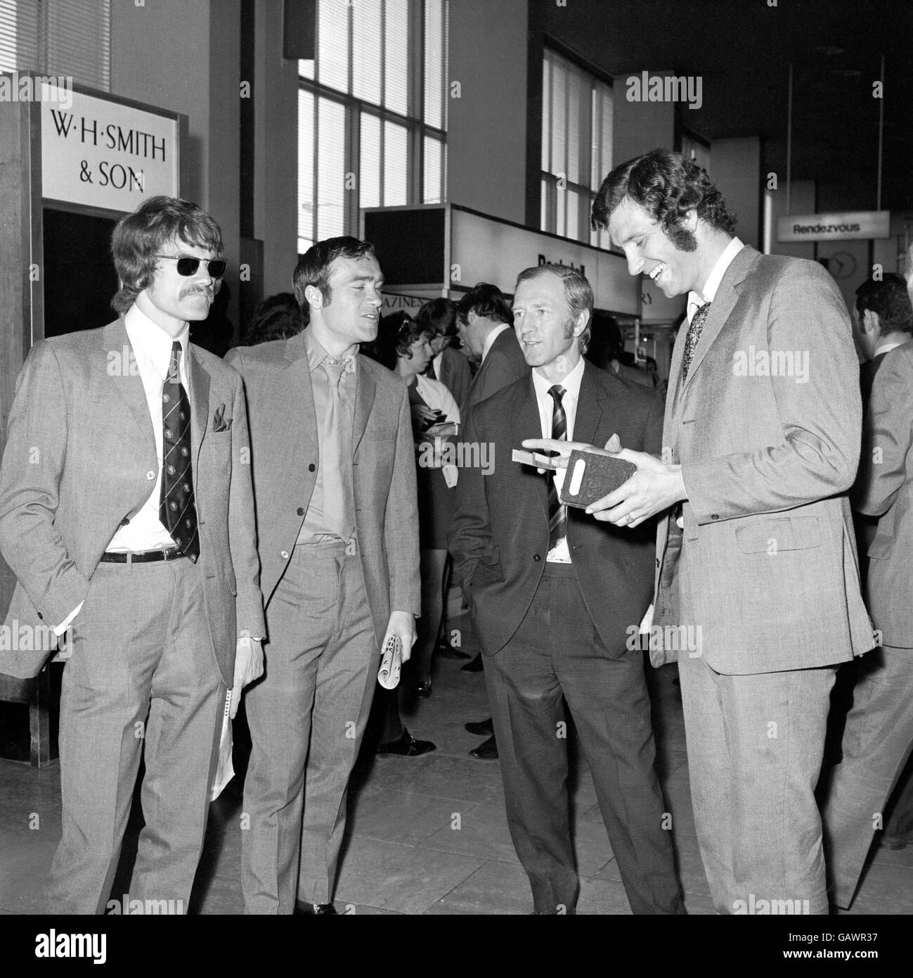 Chelsea's Peter Osgood (r) laughs at his own passport photo as he waits ...