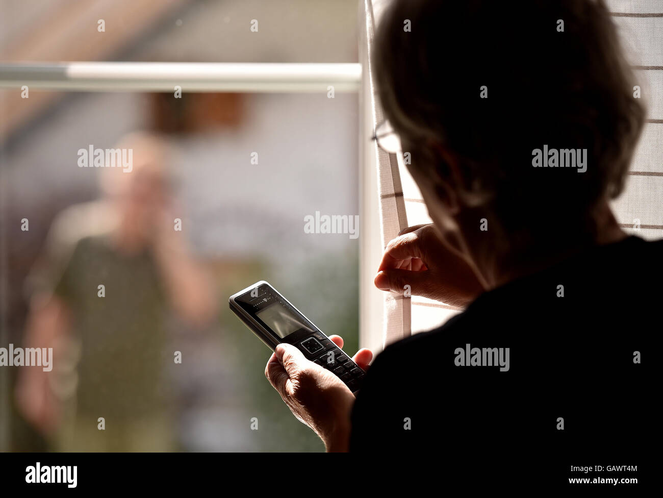 ILLUSTRATION - A stalker looking at a woman through a blurred window in ...