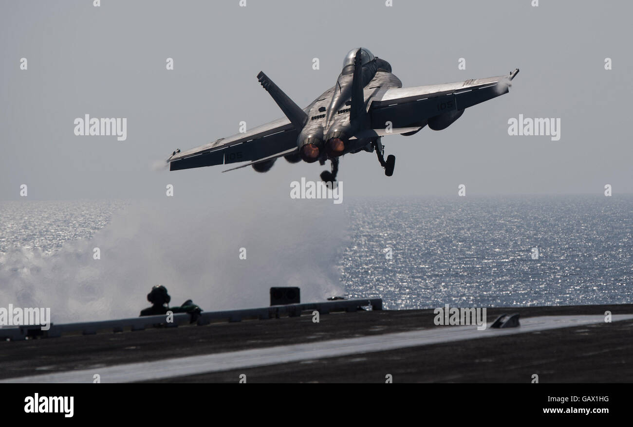 A F/A-18 E/F Superhornet takes off from the deck of aircraft carrier ...