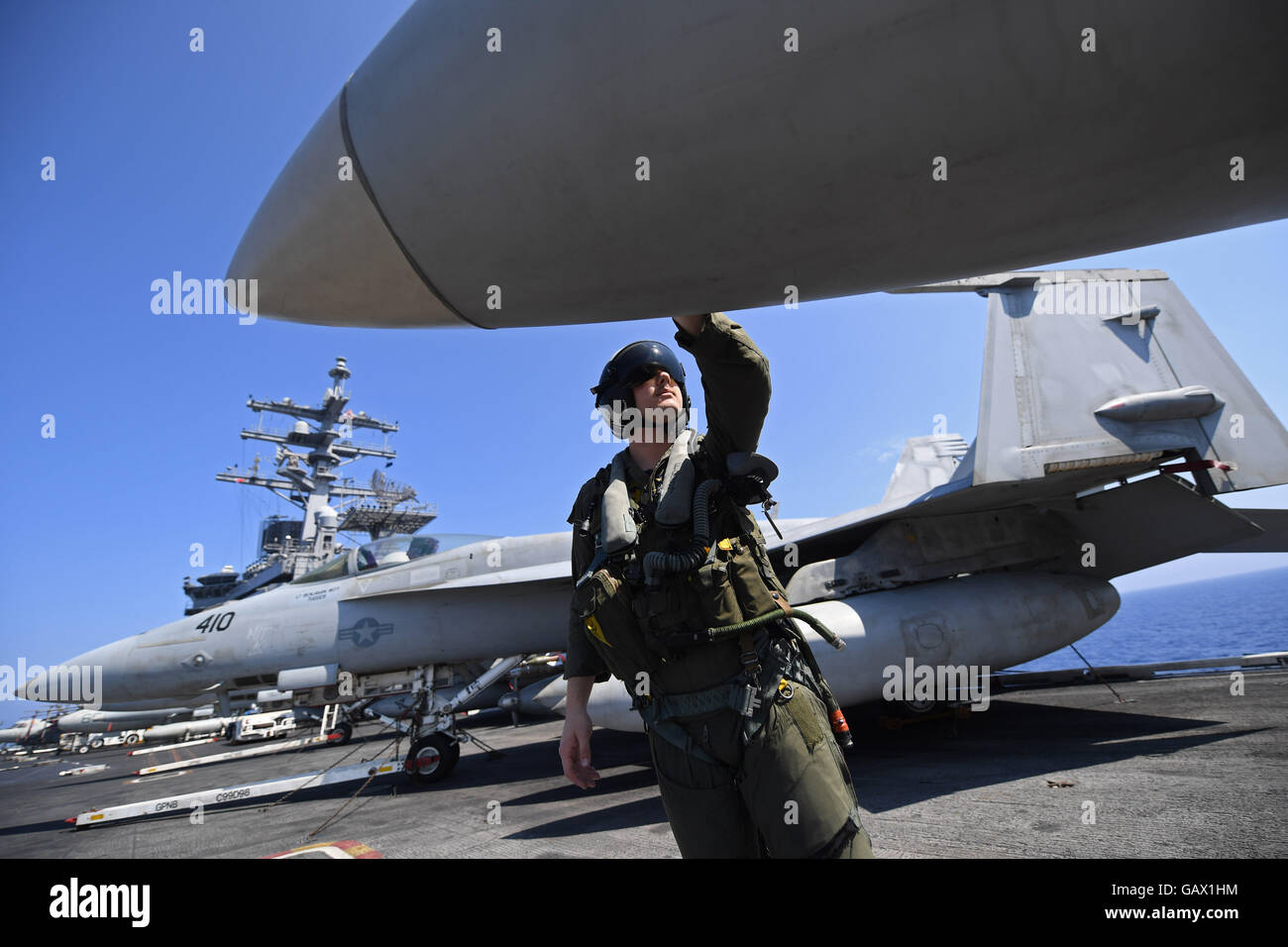 A pilot checks his warplane on the deck of aircraft carrier USS Dwight ...