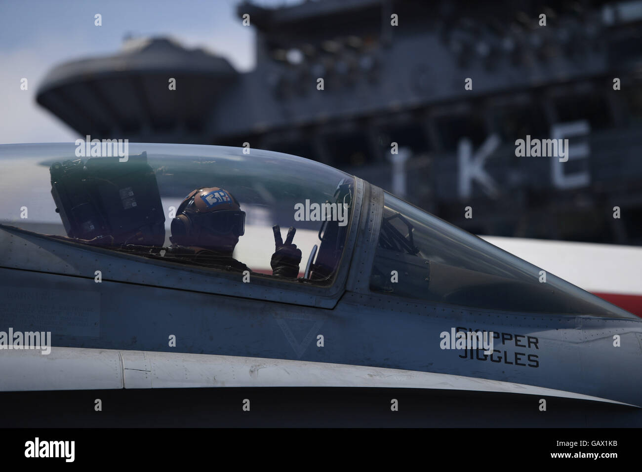 A pilot sits inside a F/A-18 E/F Superhornet on the deck of aircraft ...