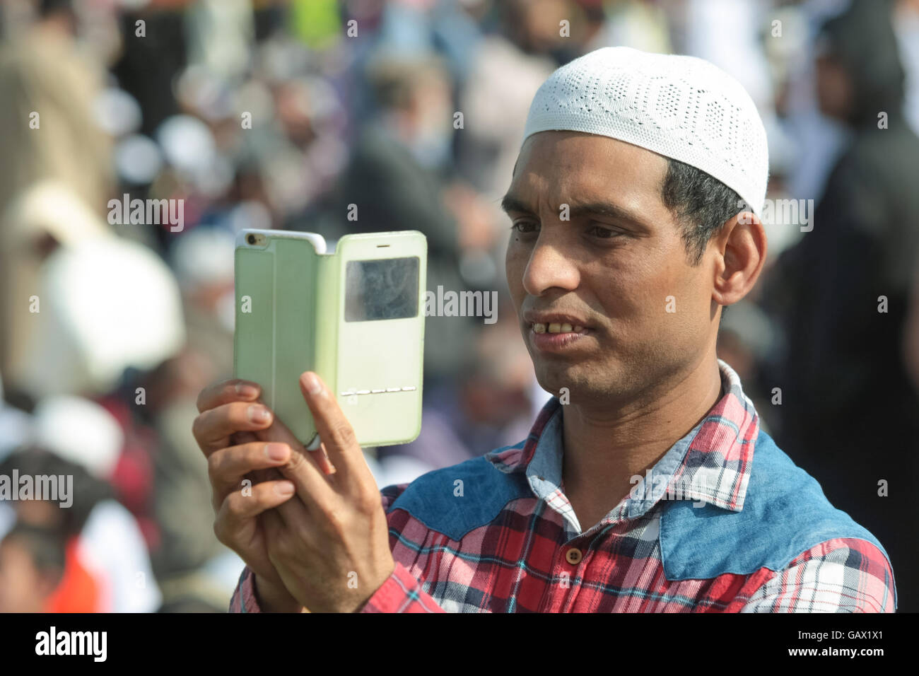 A moslem man takes a photograph on his mobile phone during the Eid ...