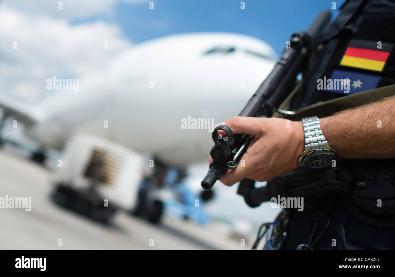 A federal police officer stands in front of an airplane with a ...