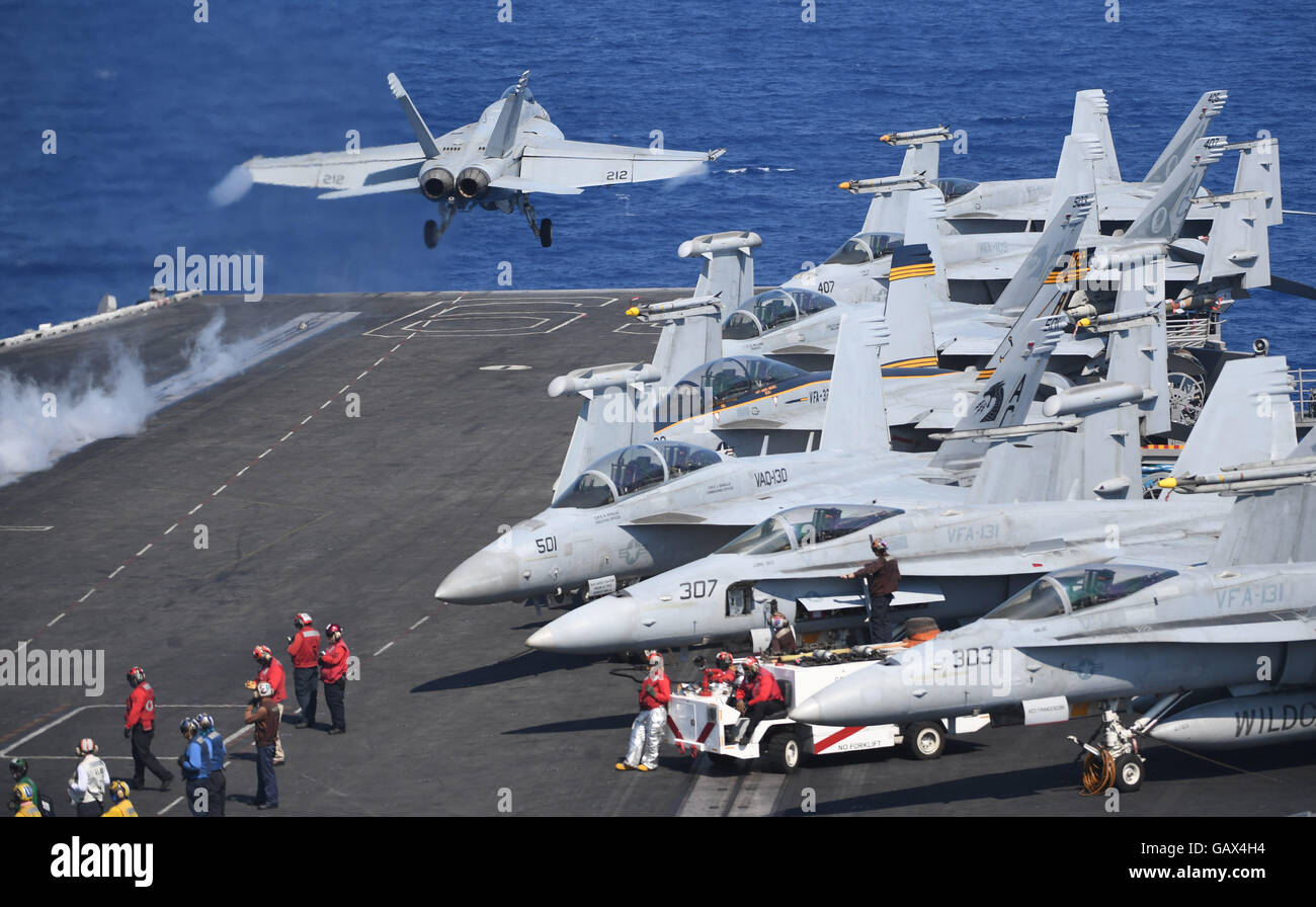 A fighter jet takes off from the deck of the aircraft carrier USS ...