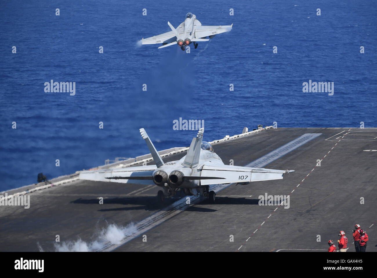 Two fighter jets take off from the deck of the aircraft carrier USS ...