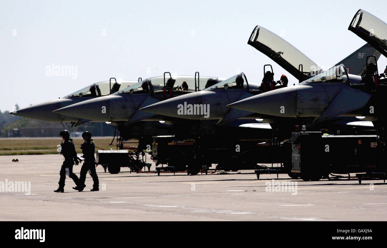 Two RAF pilots walk past a row of Typhoon fighter aircraft at RAF ...