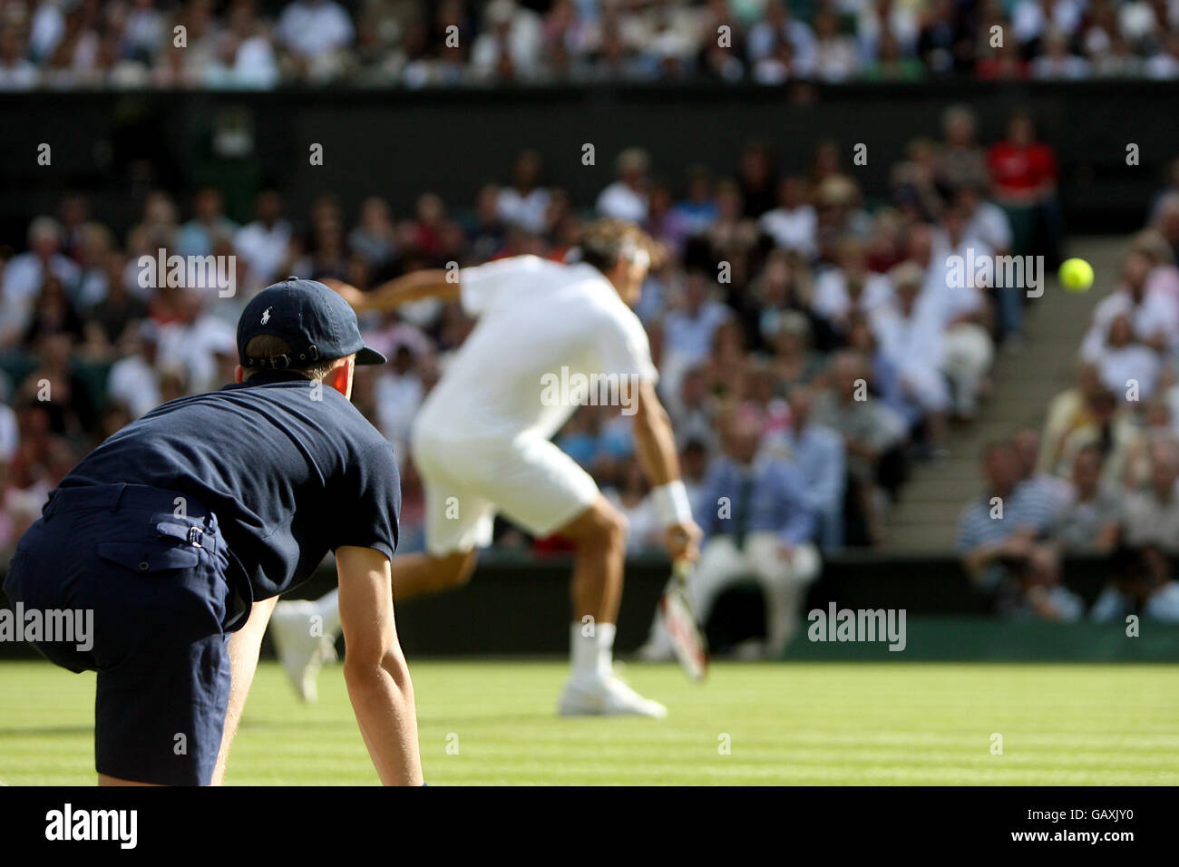 A ball boy watches the action between Switzerland's Roger Federer and ...