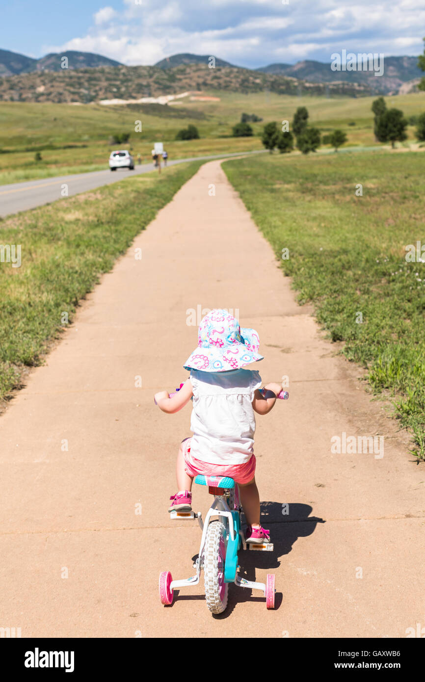 Toddler learning how to ride her first bike Stock Photo - Alamy