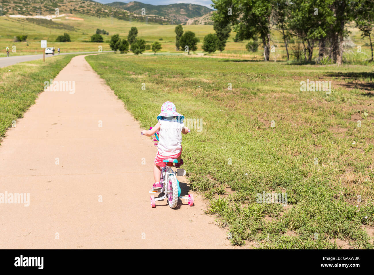 Toddler learning how to ride her first bike Stock Photo - Alamy