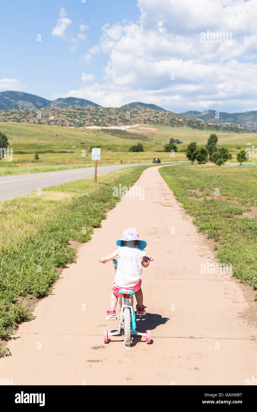 Toddler learning how to ride her first bike Stock Photo - Alamy