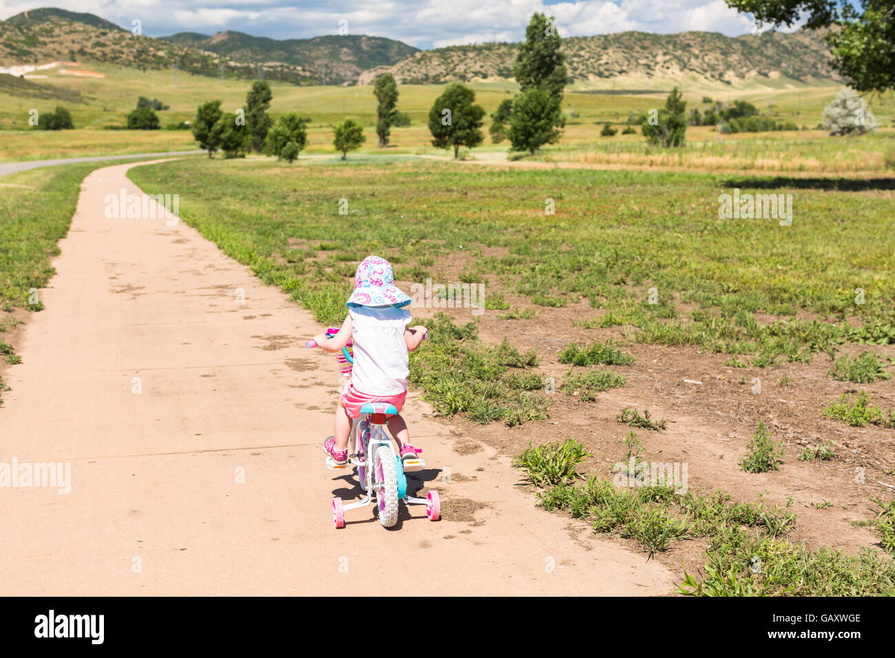 Toddler learning how to ride her first bike Stock Photo - Alamy