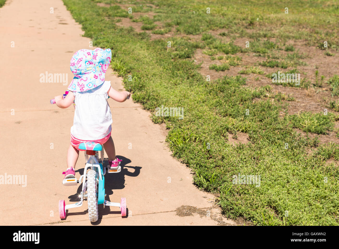 Toddler learning how to ride her first bike Stock Photo - Alamy