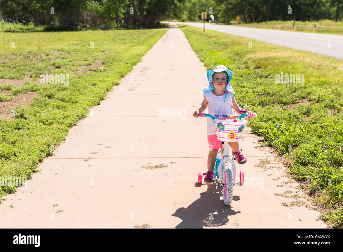 Toddler learning how to ride her first bike Stock Photo - Alamy