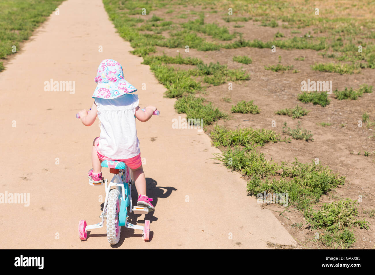 Toddler learning how to ride her first bike Stock Photo - Alamy