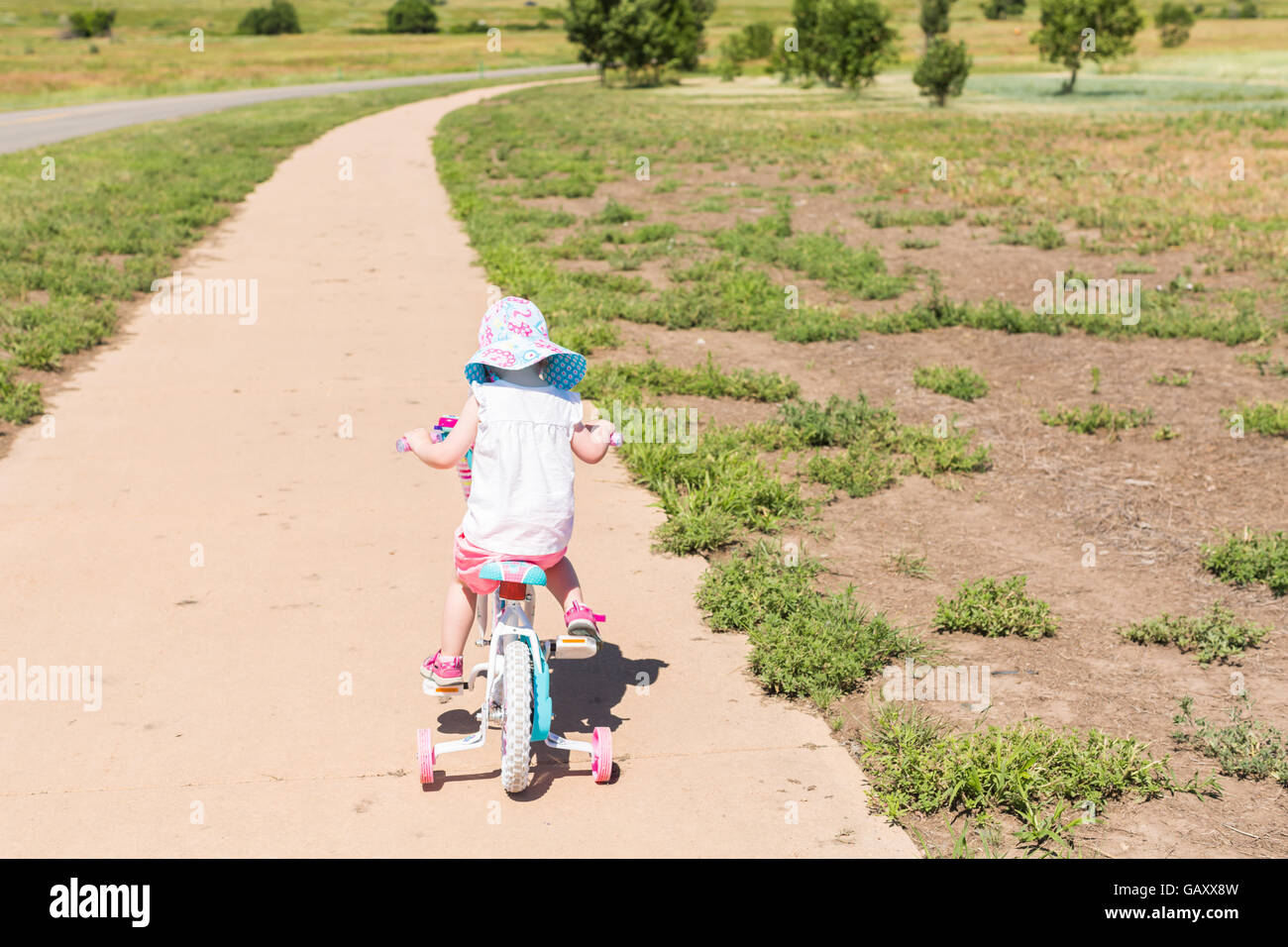 Toddler learning how to ride her first bike Stock Photo - Alamy