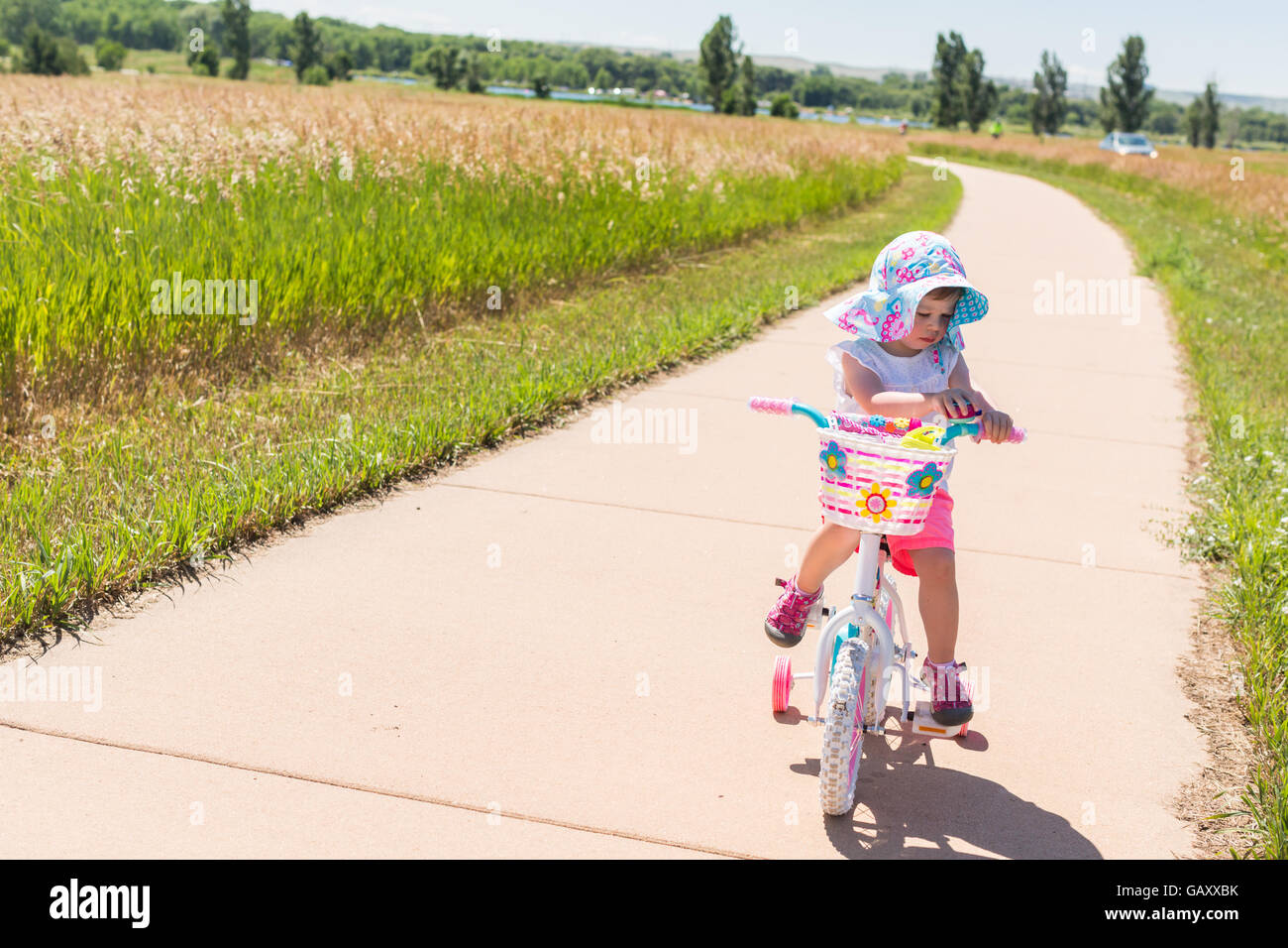 Toddler learning how to ride her first bike Stock Photo - Alamy